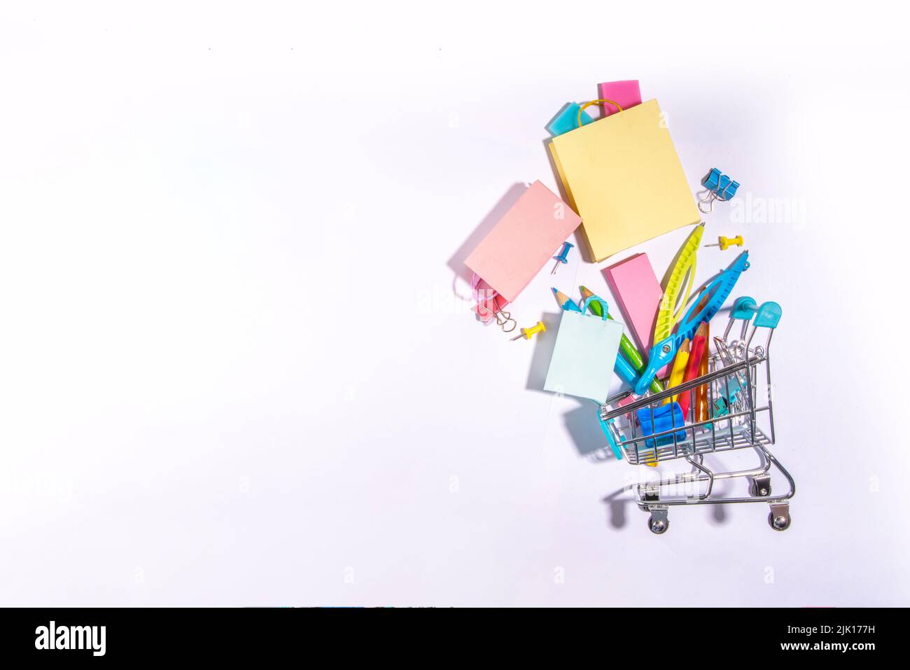 School sale concept. Shopping supermarket cart with colorful paper bags ...