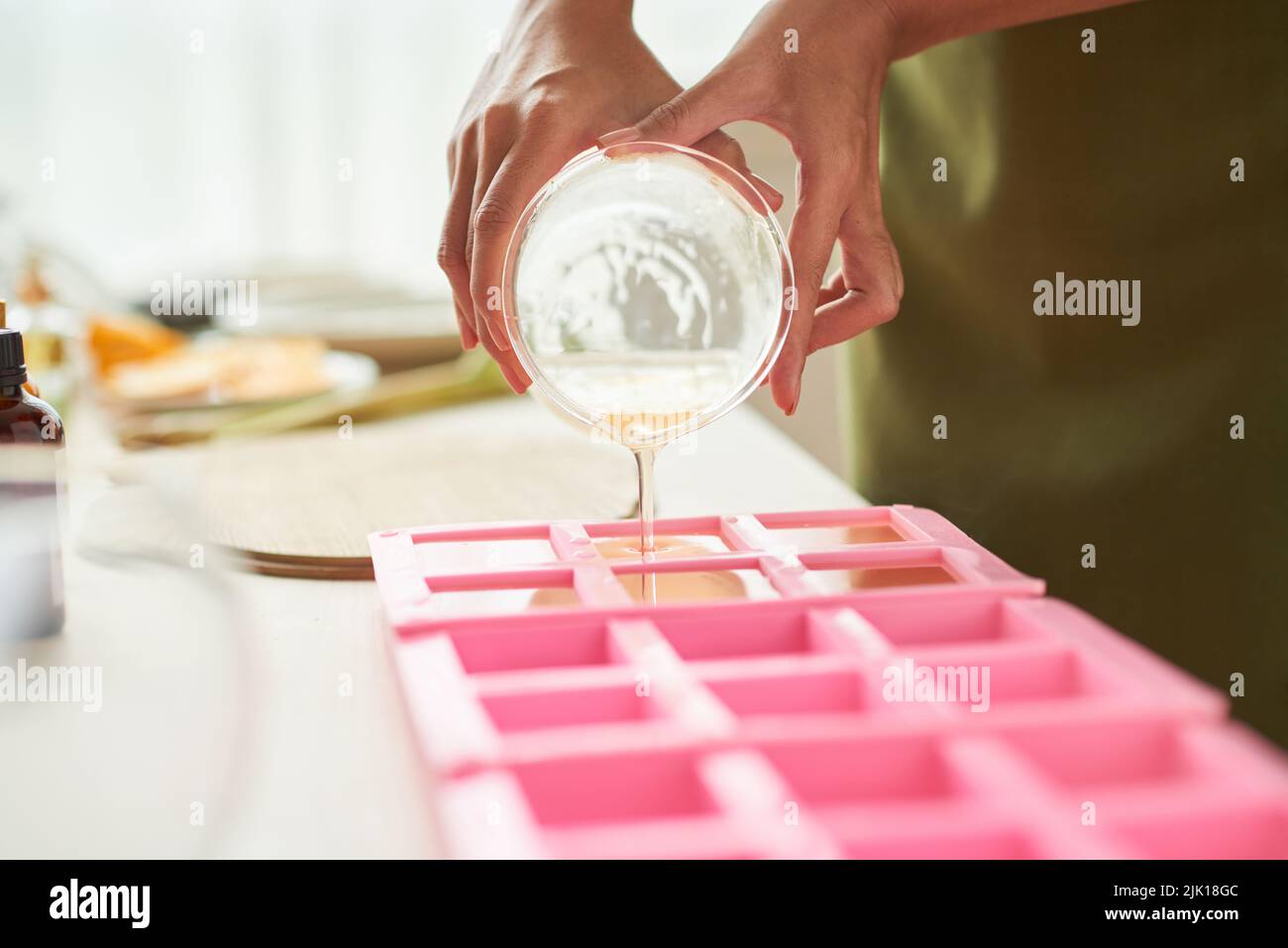 Close-up image of woman pouring soap mixture into plastic form Stock ...