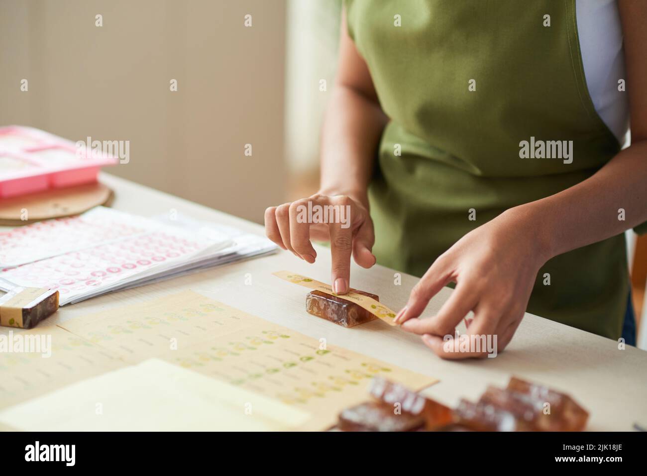 Hands of woman glueing label onto soap bar she made Stock Photo - Alamy
