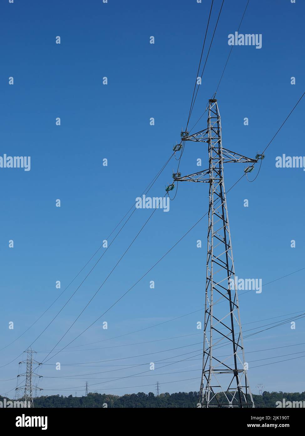 A vertical shot of transmission towers against a blue sky Stock Photo ...