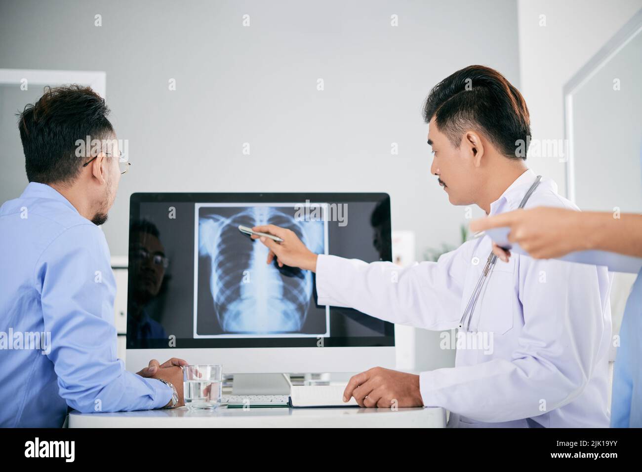 Doctor explaining results of chest x-ray to patient Stock Photo - Alamy