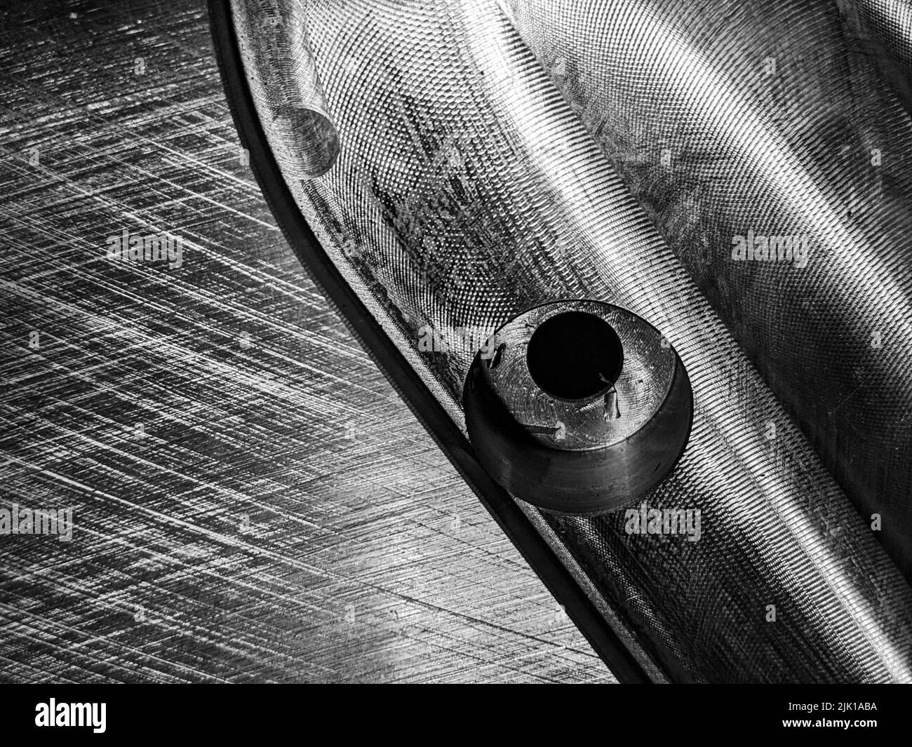 A closeup grayscale shot of a metal object with brushed and shiny ...