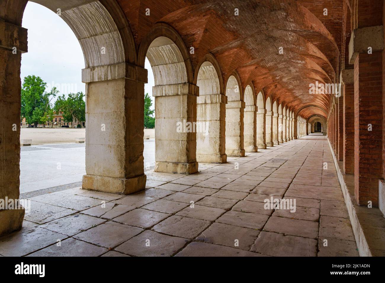Large symmetrical exterior corridor with arches and columns in the old ...