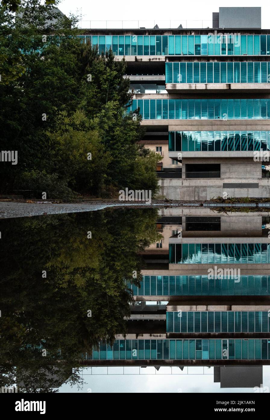 A reflecting blue resident house with trees reflecting on lake water ...