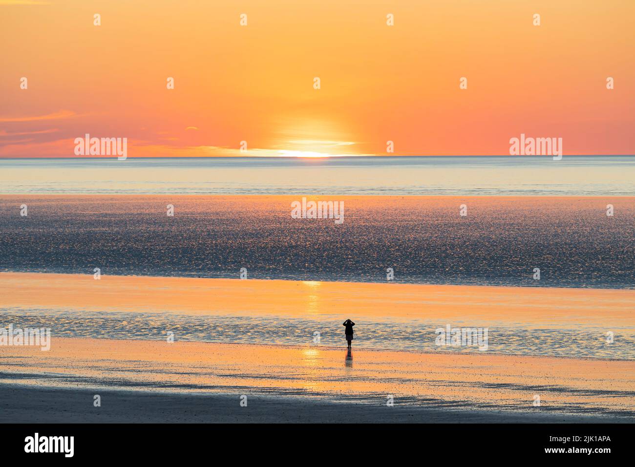 A lday is enjoying the beautiful view at 80 mile beach, in Broome ...