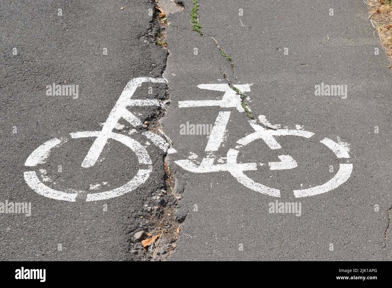 bike road sign with bad cracks in the asphalt Stock Photo - Alamy