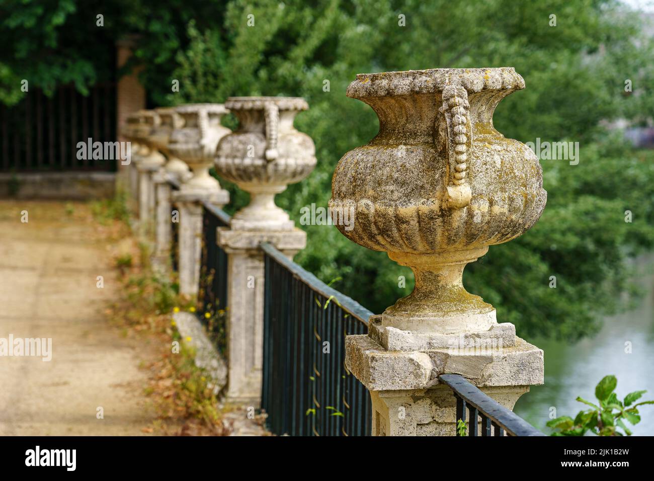 Public park walk along the Tagus river and iron fence with ancient ...