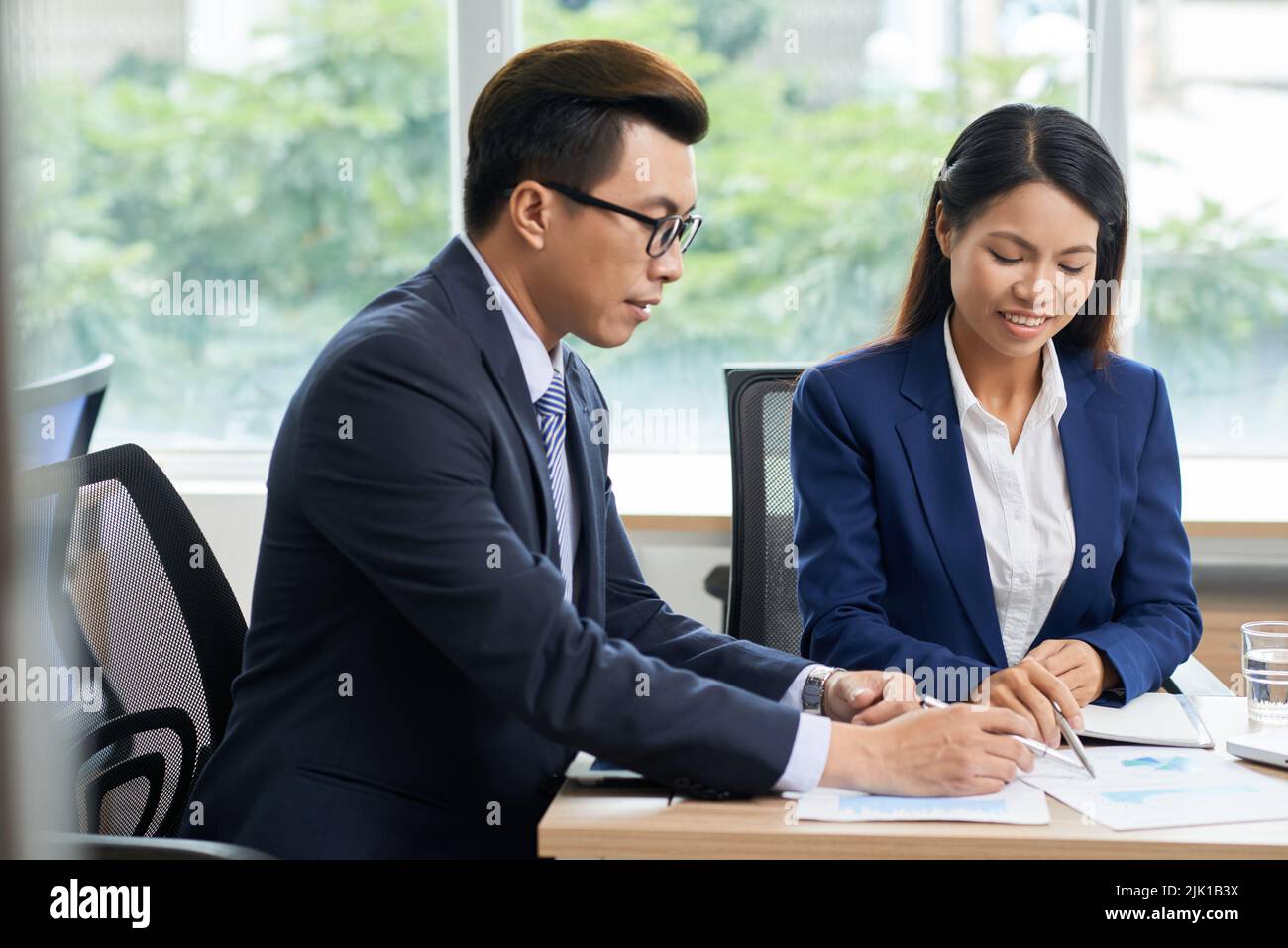 Vietnamese business people checking information in financial documents ...