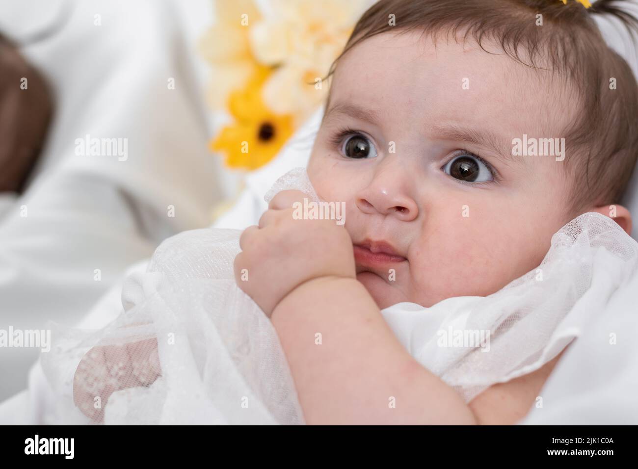 close up of a beautiful latin baby girl with an impressed face looking ...