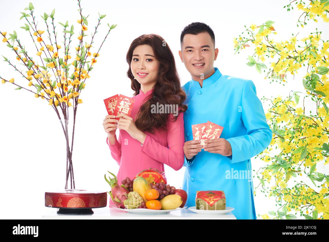 Smiling young couple in traditional dresses holding lucky money ...