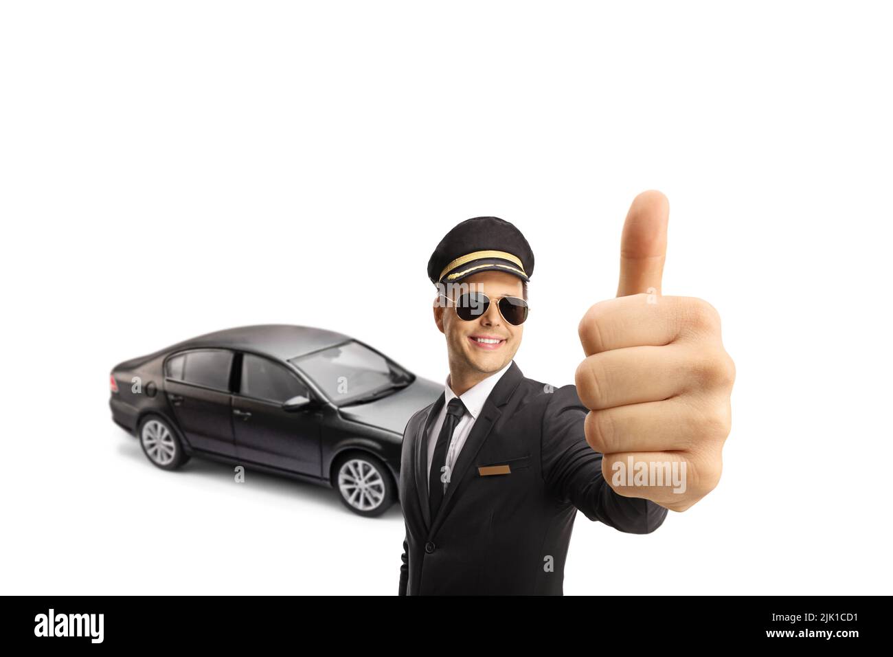 Professional chauffeur with a black car gesturing thumbs up isolated on ...