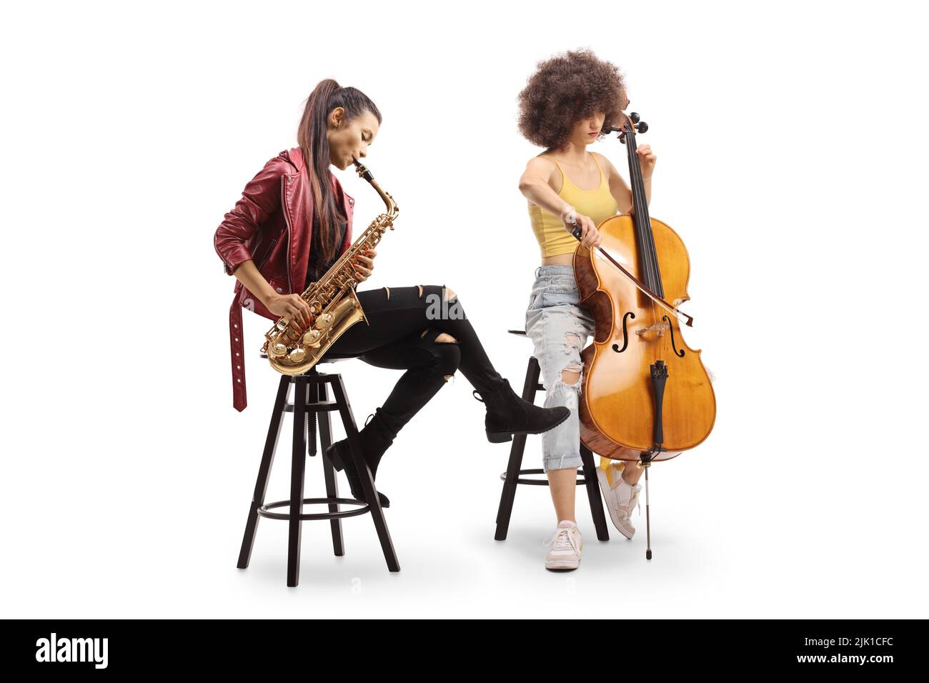 Two young women playing a cello and a sax isolated on white background ...
