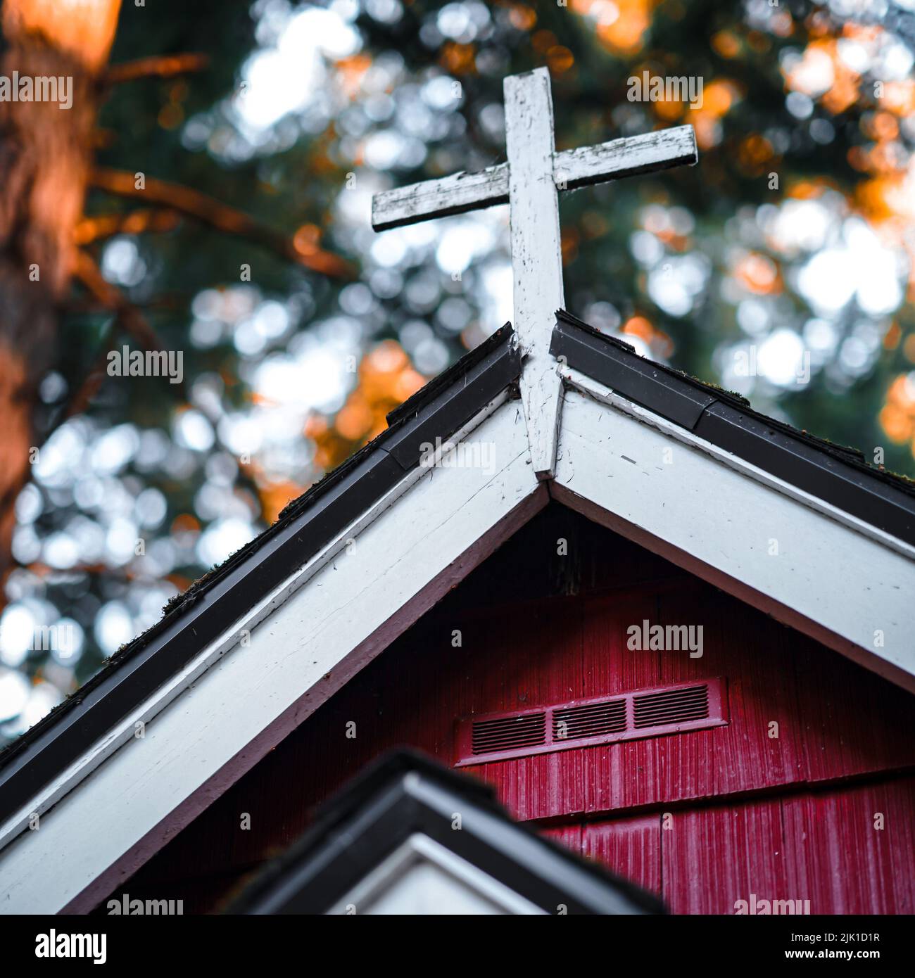 A wooden cross on a top of a house with bokeh background Stock Photo ...
