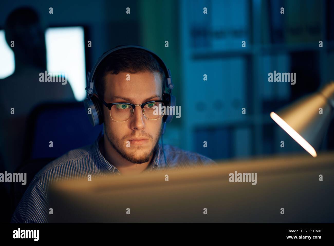 Software developer listening to music and working on computer late at night Stock Photo - Alamy