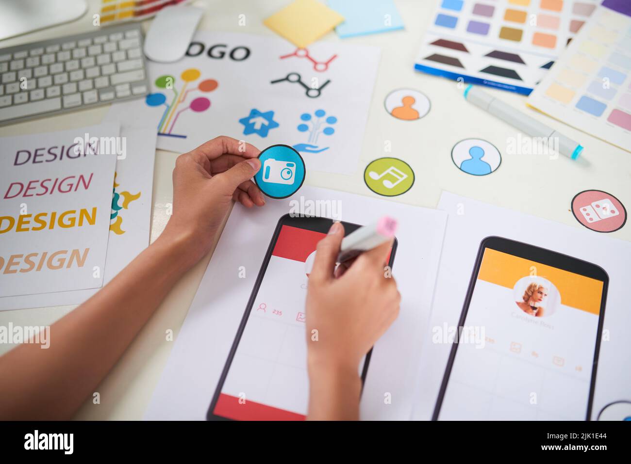 Creative young worker sitting at office desk and making colorful ...