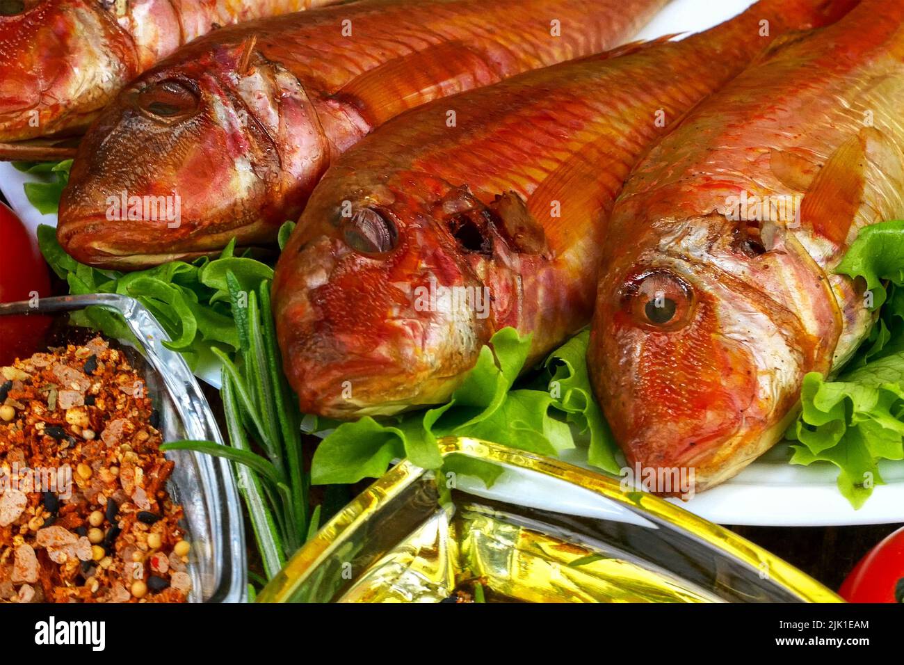 Smoked whole sea fish served salad leaves with vegetable and spices on ...