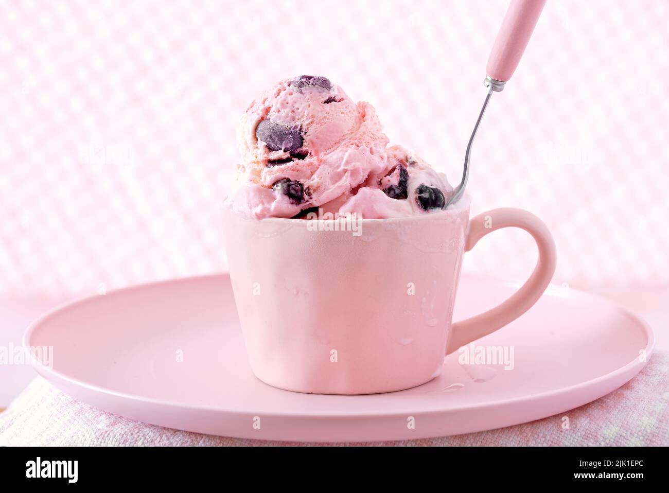 Scoops of black cherry ice cream in a pink cup featuring a pink color ...