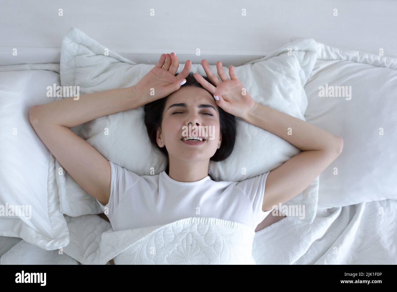 Top view, depressed woman lying in bed crying and screaming with ...