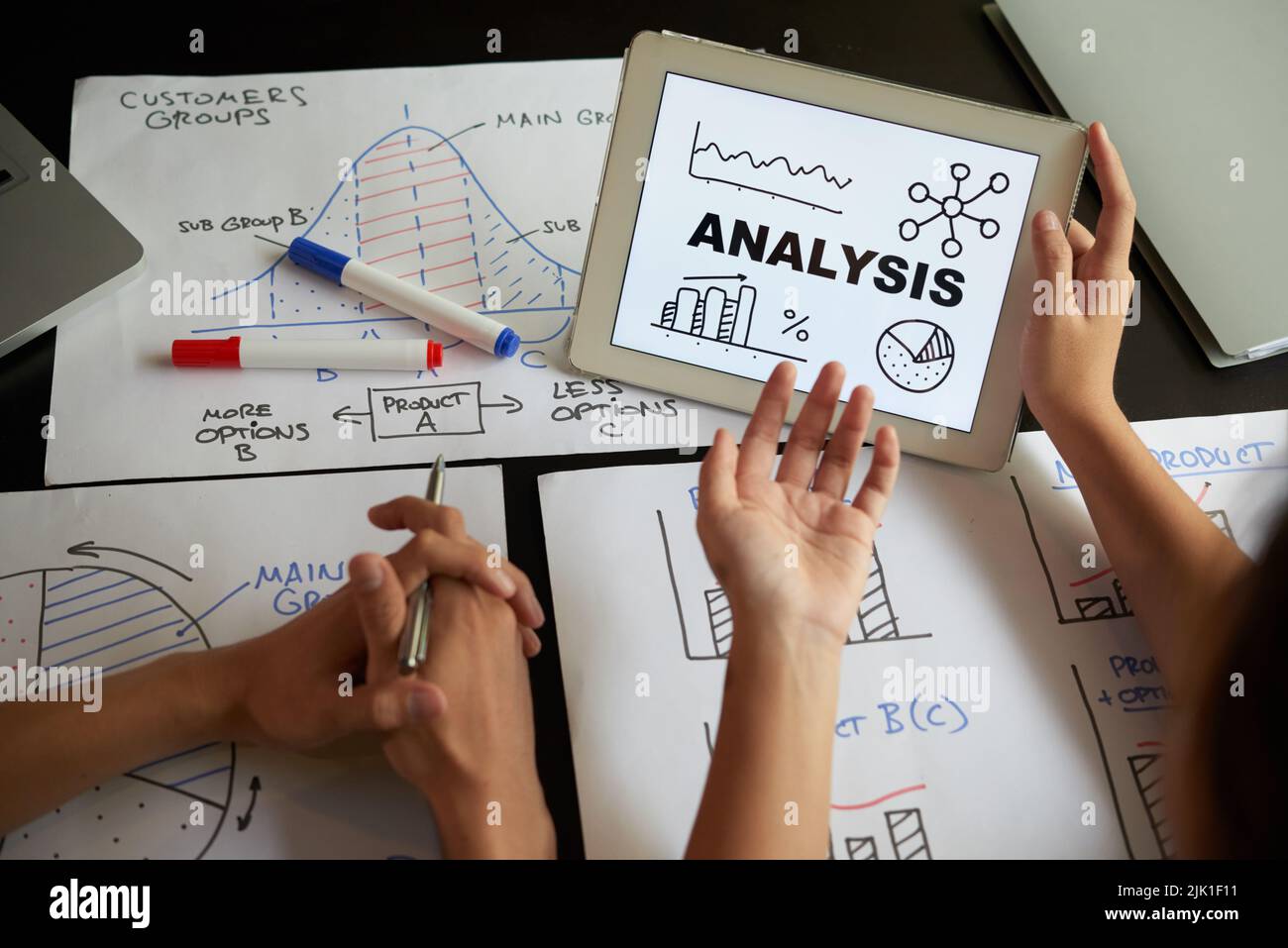 Various charts and graphs on table of business people whe are having ...