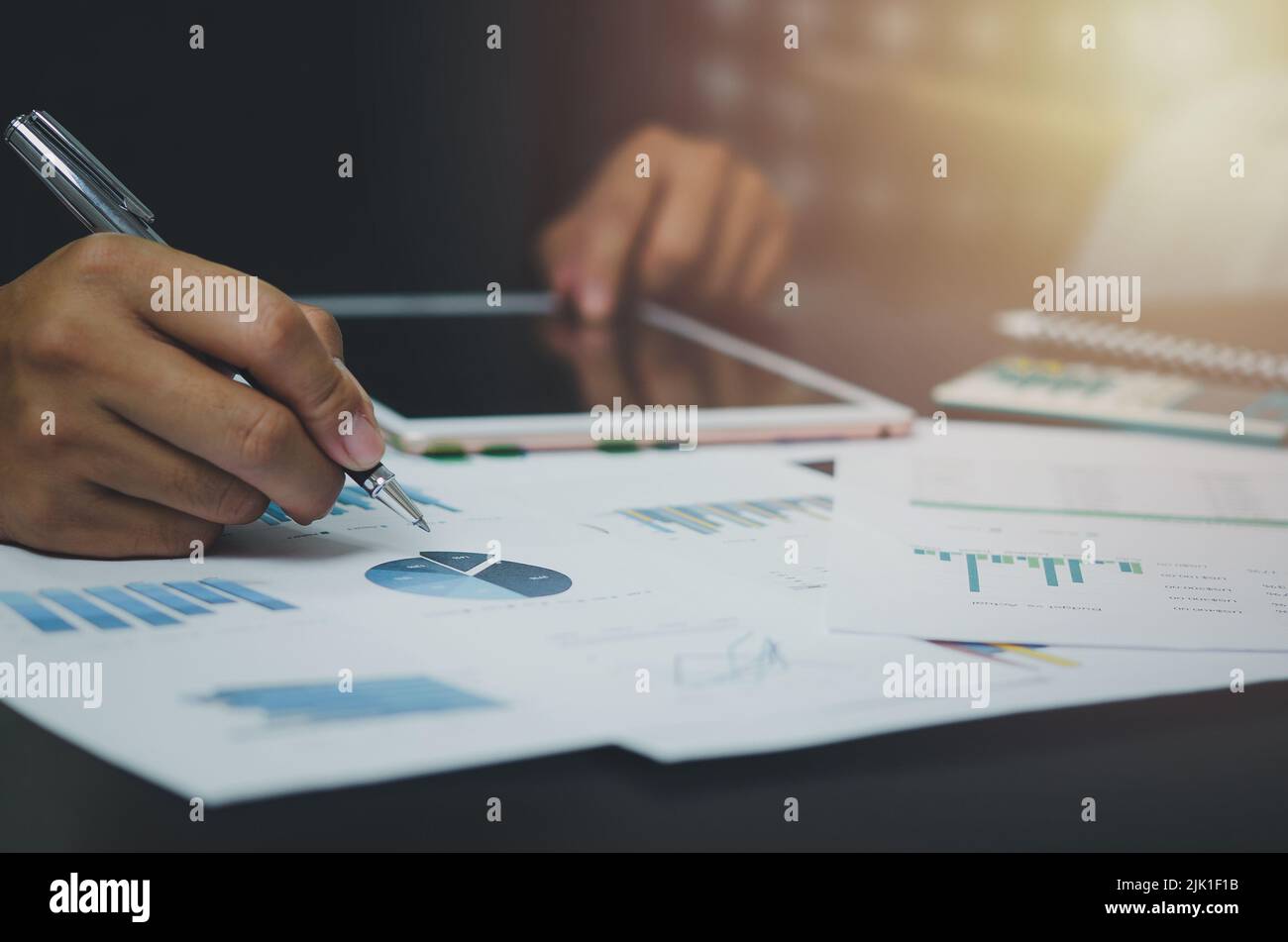 Businessman hand holding pen pointing paperwork chart report analysis ...