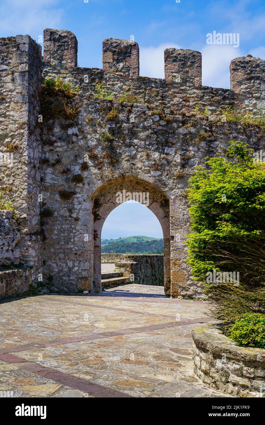Medieval castle with stone wall and arched entrance gate in sunny day ...