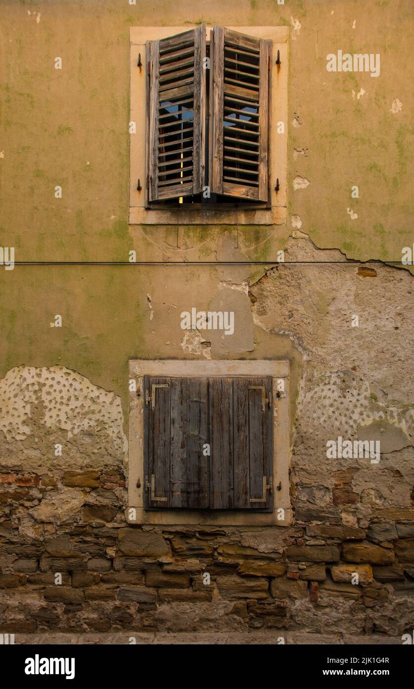 Shuttered windows in a derelict stone residential building in the ...