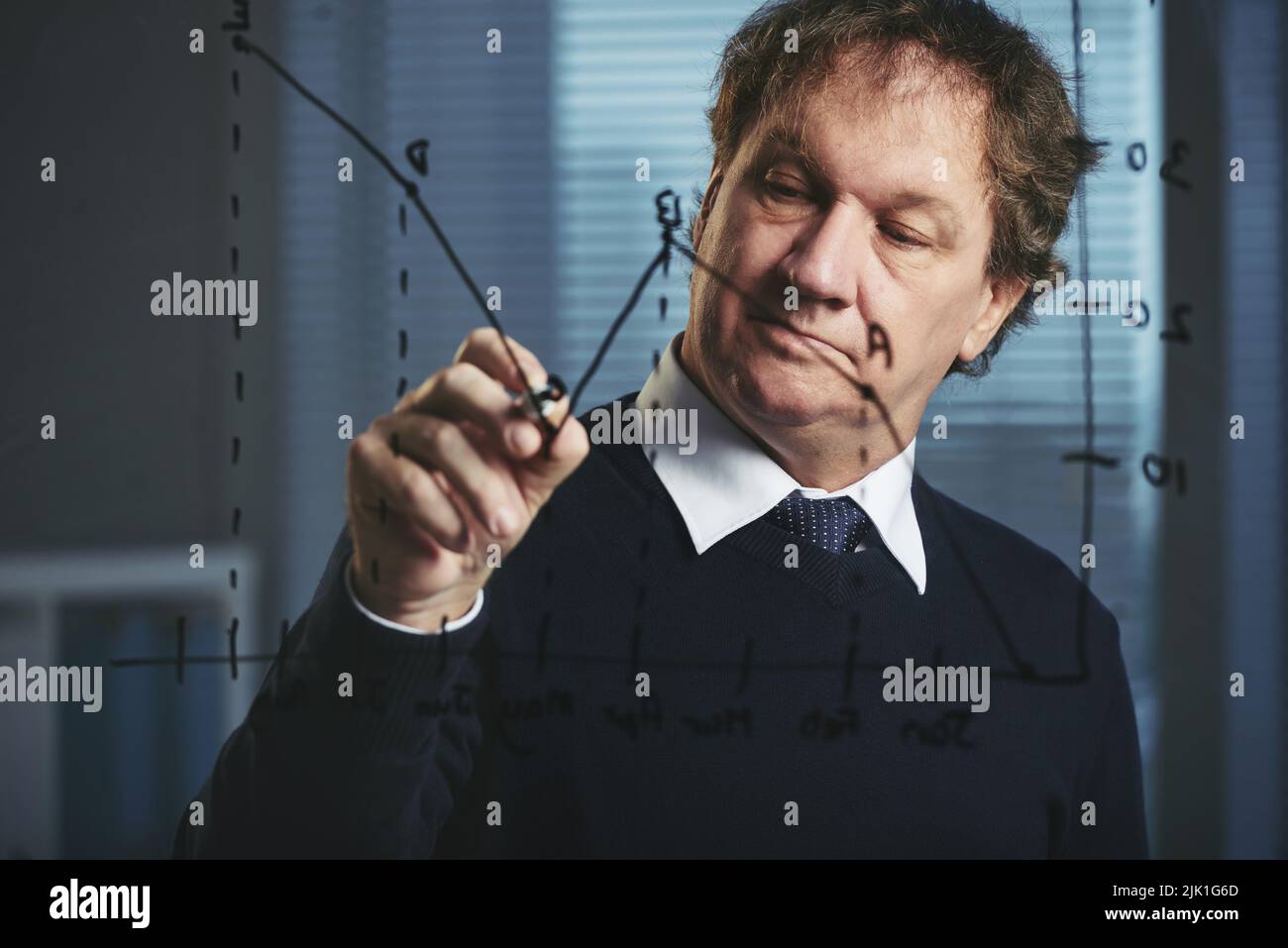 Businessman drawing sales graph in glass wall Stock Photo - Alamy