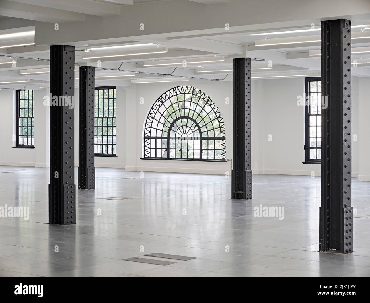 Unfurnished office space with original features and arched window. The ...