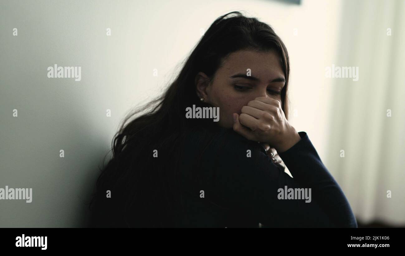 Troubled woman suffering alone with anxiety sitting on floor at home ...