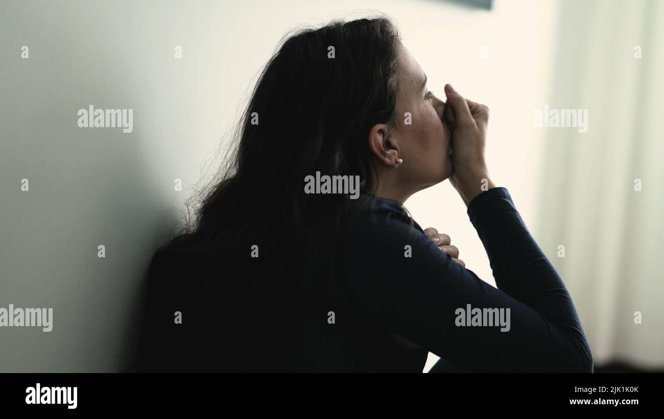 Troubled woman suffering alone with anxiety sitting on floor at home ...