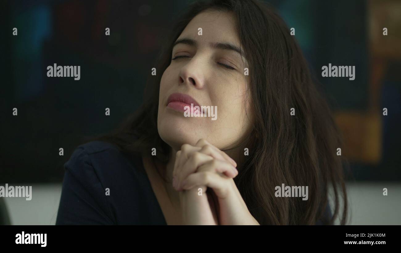 Woman with preoccupied expression closing eyes with regret. Person remembering past Stock Photo ...