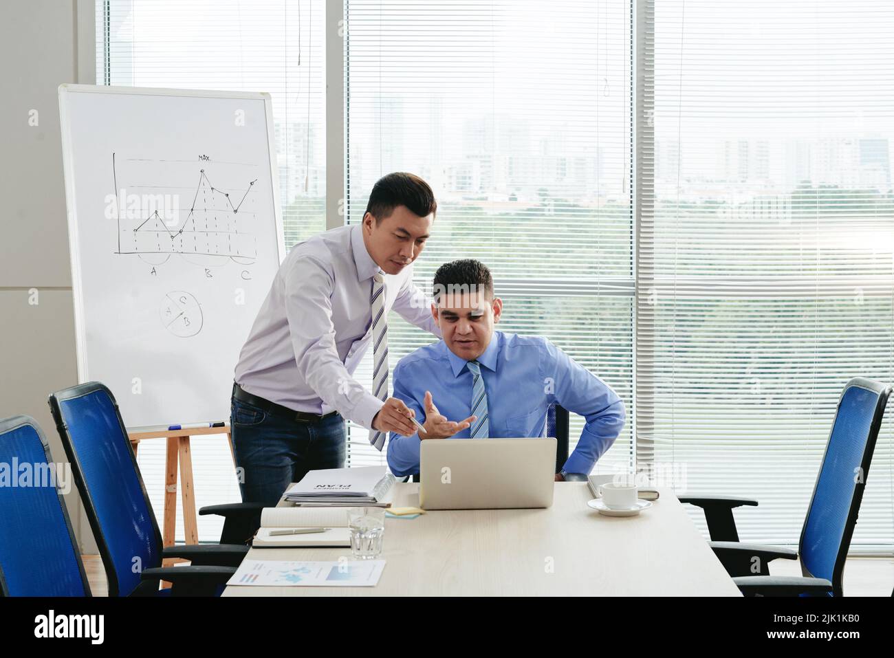 Vietnamese businessman helping his coworker with work Stock Photo - Alamy