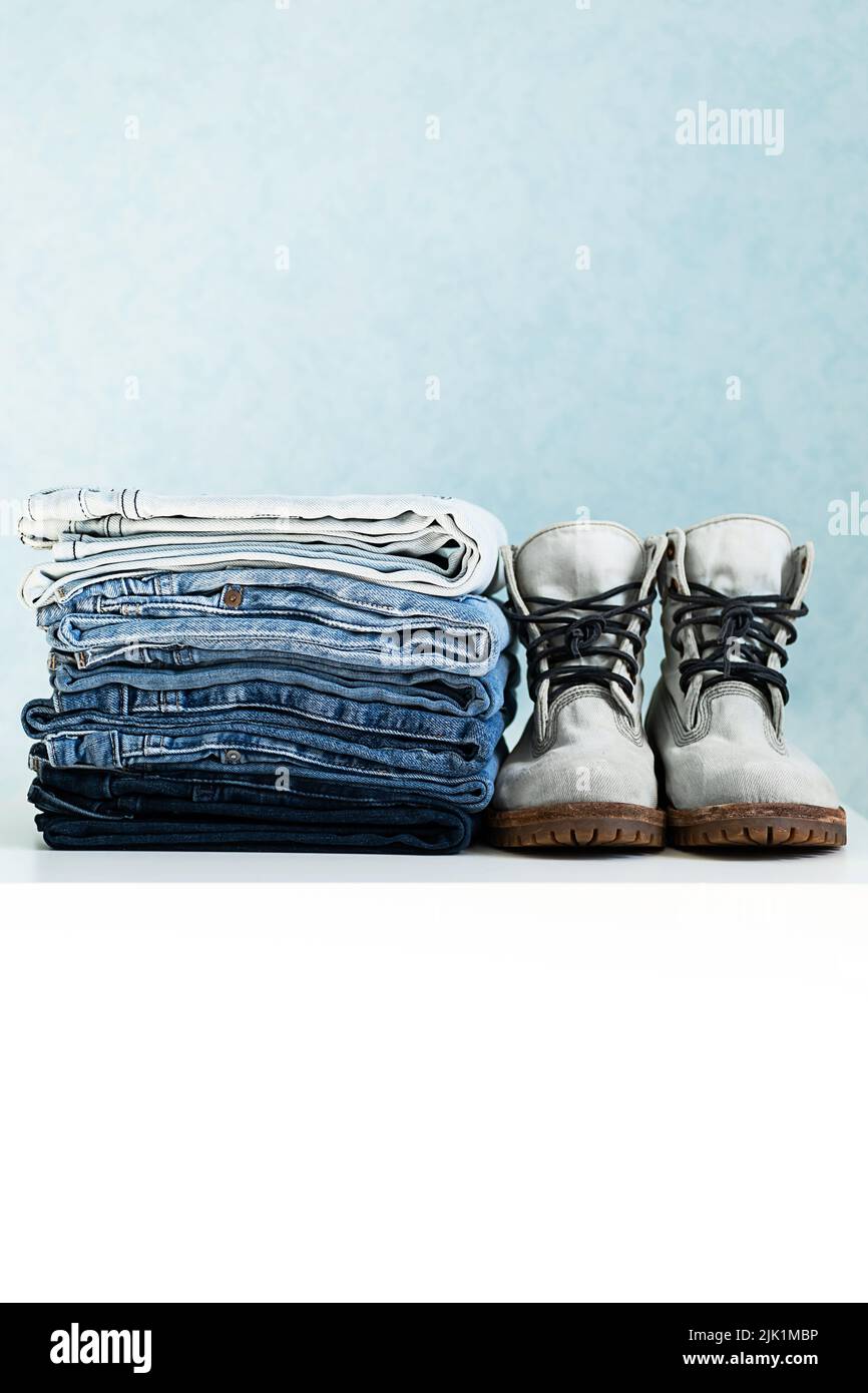 Denim Collection. Stack of jeans and pair of boots. Casual clothing ...