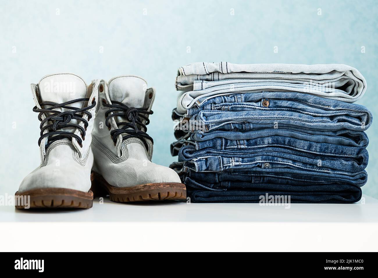 Denim Collection. Stack of jeans and pair of boots. Casual clothing ...
