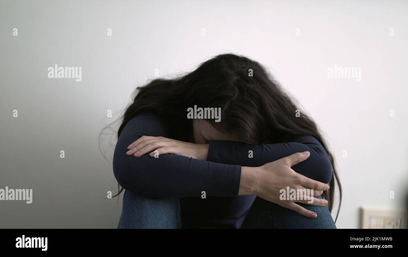 Depressed female person covering face in shame remembering trauma ...