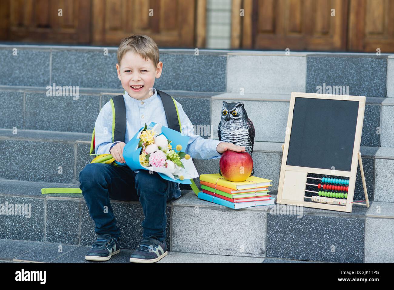 First-grader boy is sitting with a backpack on the doorstep of the ...