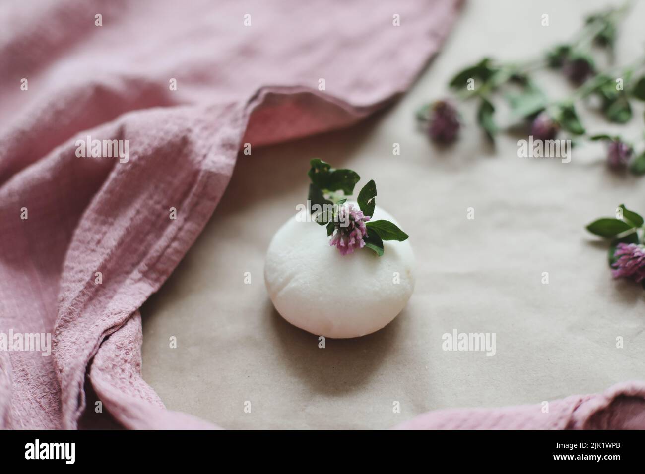 Natural organic soap with flowers and pink towel on craft paper ...