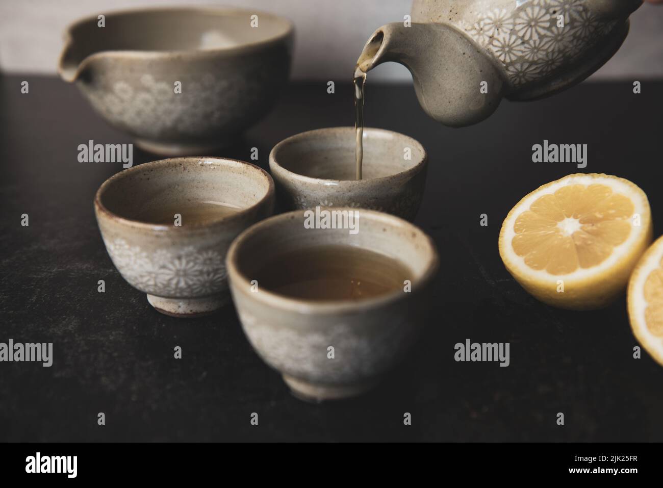 Pouring Korean tea into teacups with lemon and loose leaf tea Stock ...