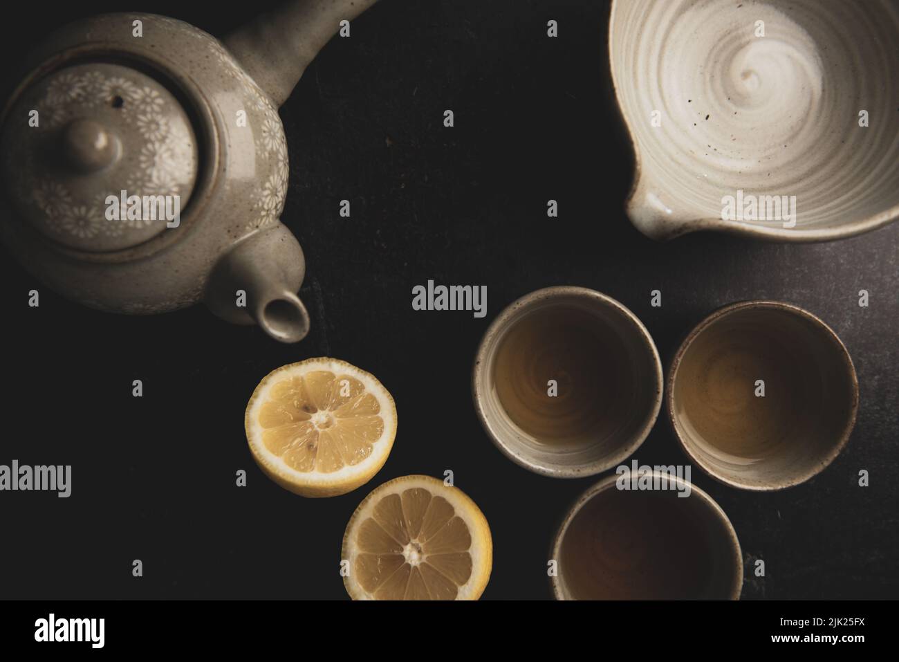 Korean teapot and teacups with lemon and loose leaf tea. Lay flat view ...