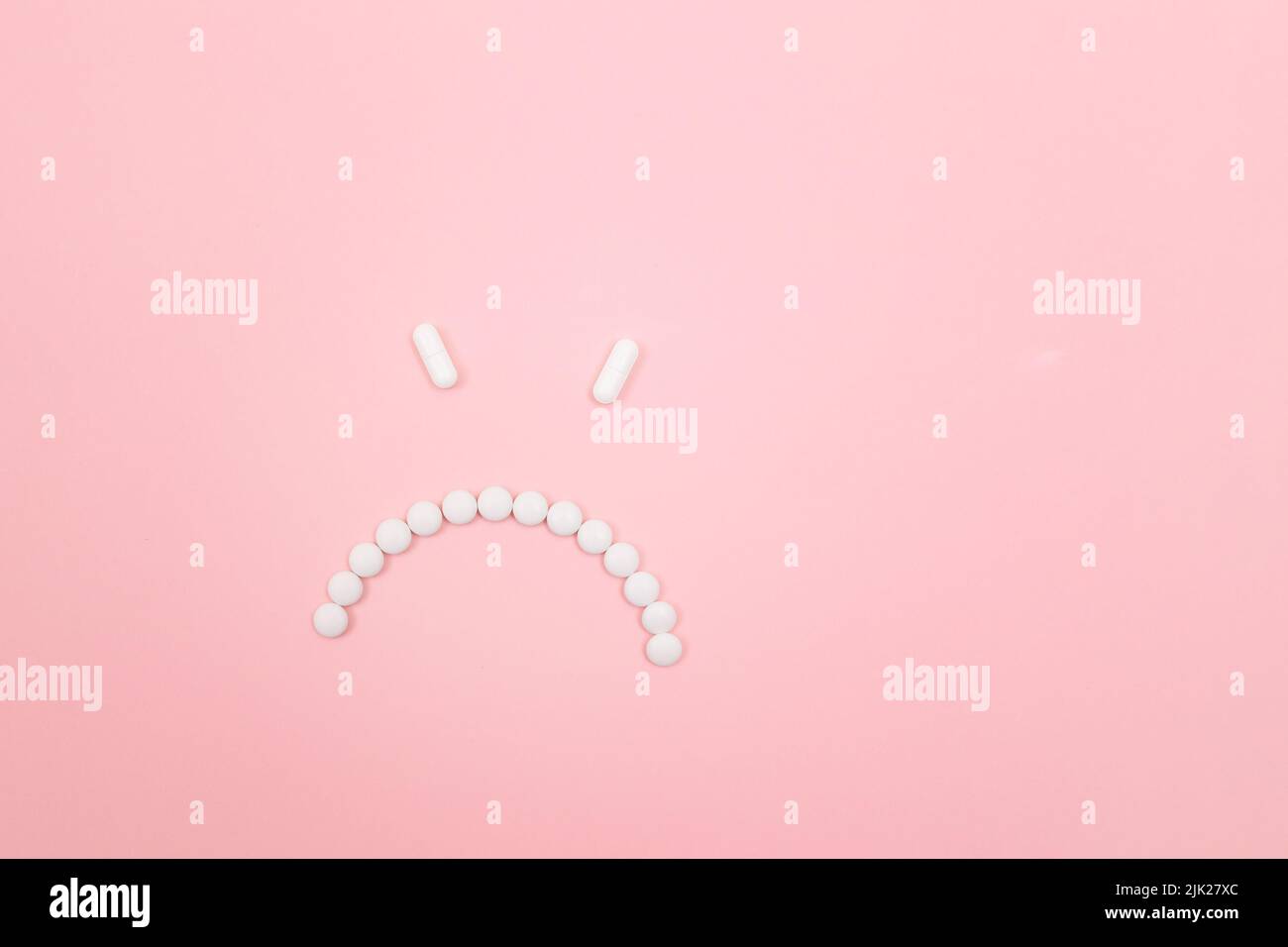Pharma Harm. Angry Smiley Face Made from White Pills, Lying on Pink ...