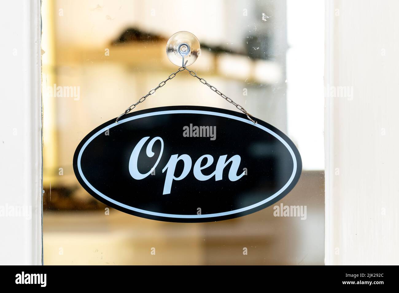 Shop door oval open sign hanging on glass entrance to retail business ...