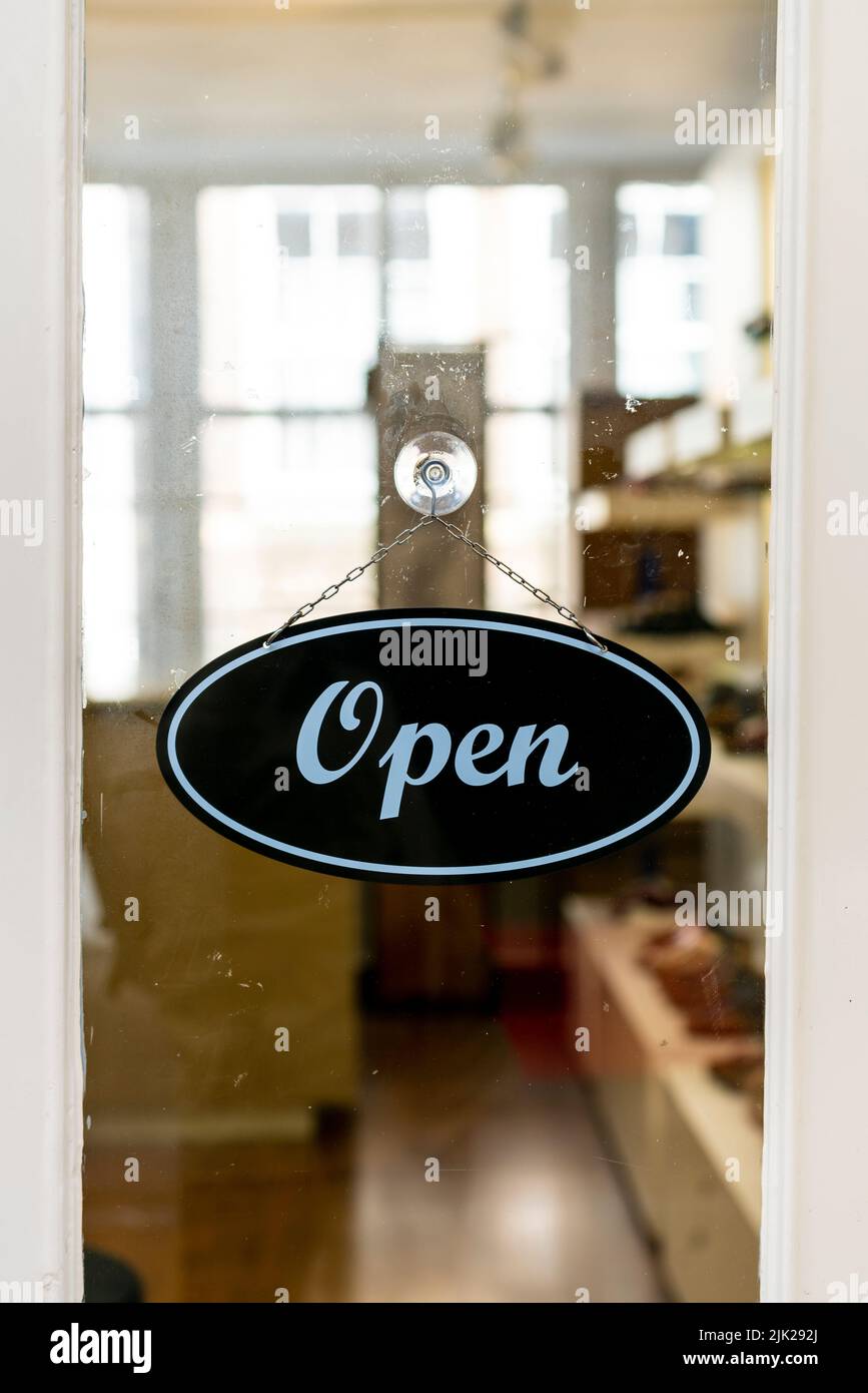 Shop door oval open sign hanging on glass entrance to retail business ...