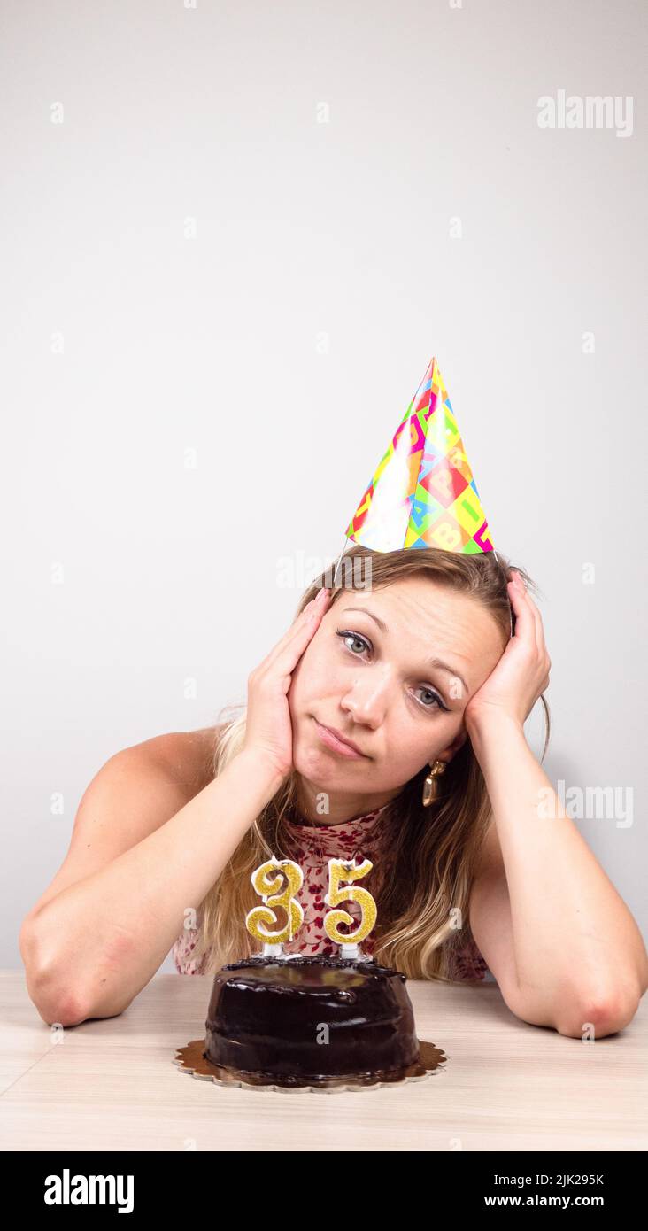 a woman celebrates her birthday alone. beautiful sad woman clebrating ...