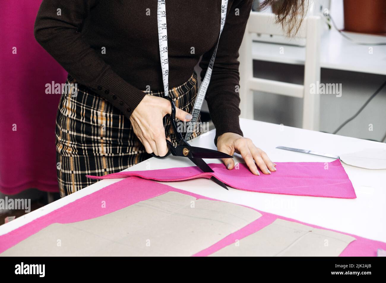 Female fashion designer tailor making sewing patterns at workplace in ...