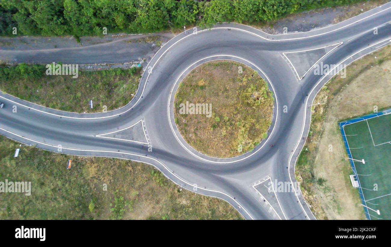 Top down aerial view of a traffic roundabout on a main road in an urban ...