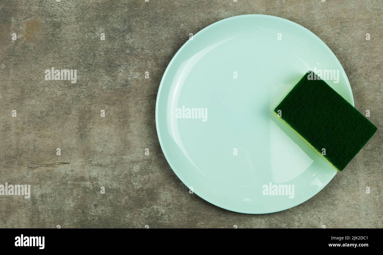 Cleaning sponge on a green plate on a gray background Stock Photo - Alamy