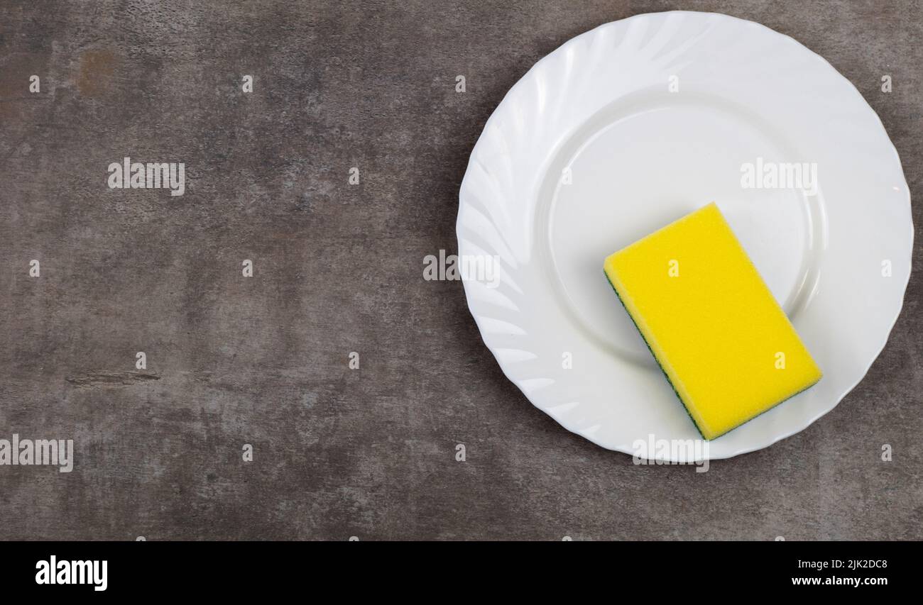 Cleaning sponge on white plate on gray background Stock Photo - Alamy