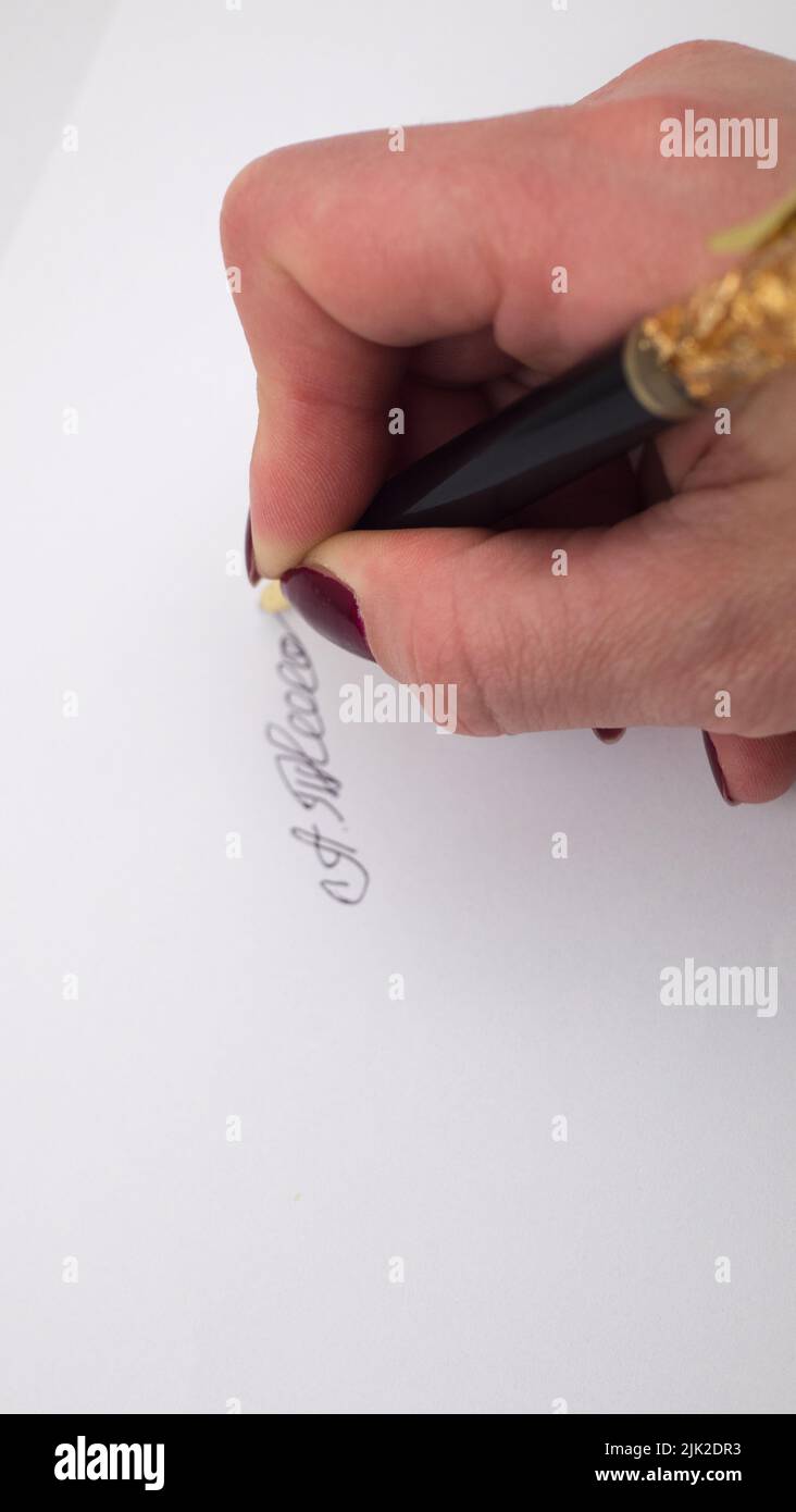 Female hand signing business papers. Close-up of woman signing document ...
