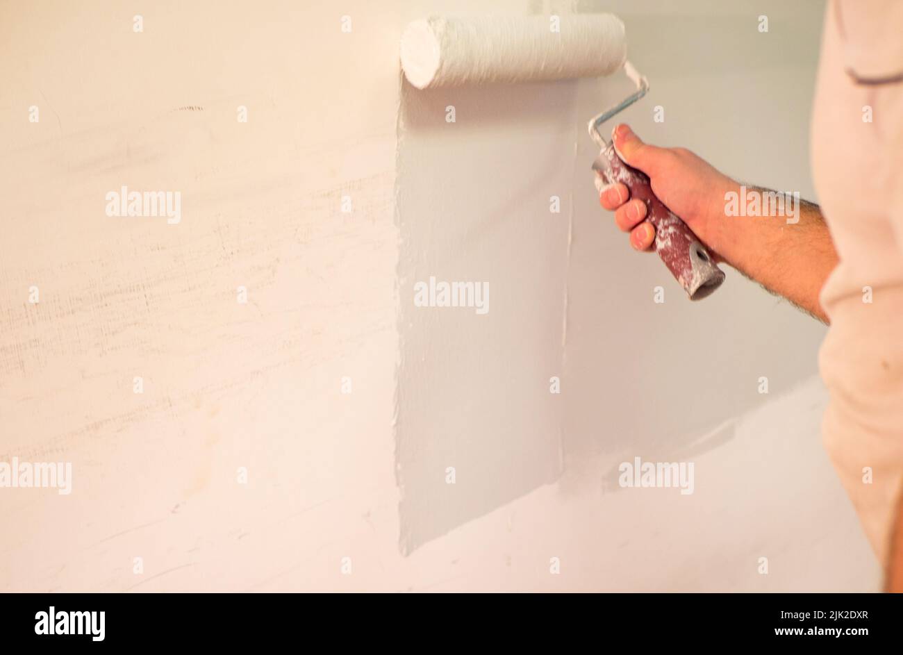Decorators hand painting wall with roller Stock Photo - Alamy