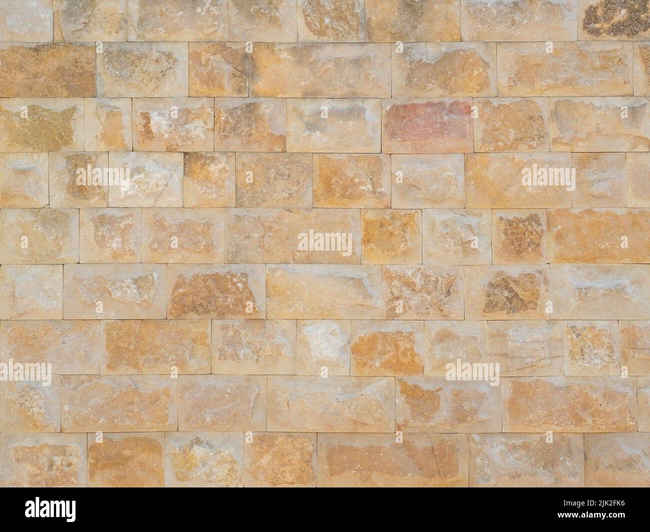 Facade cladding. Wall with orange rough masonry. Full screen photo. Not ...